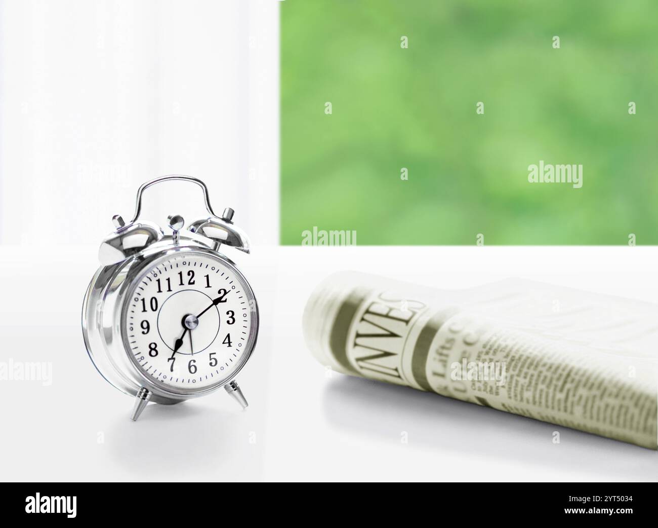 Alarm clock and newspaper on the windowsill Stock Photo - Alamy