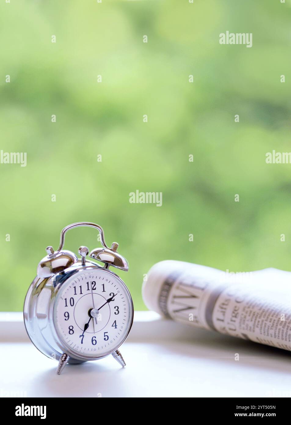 Alarm clock and newspaper Stock Photo - Alamy