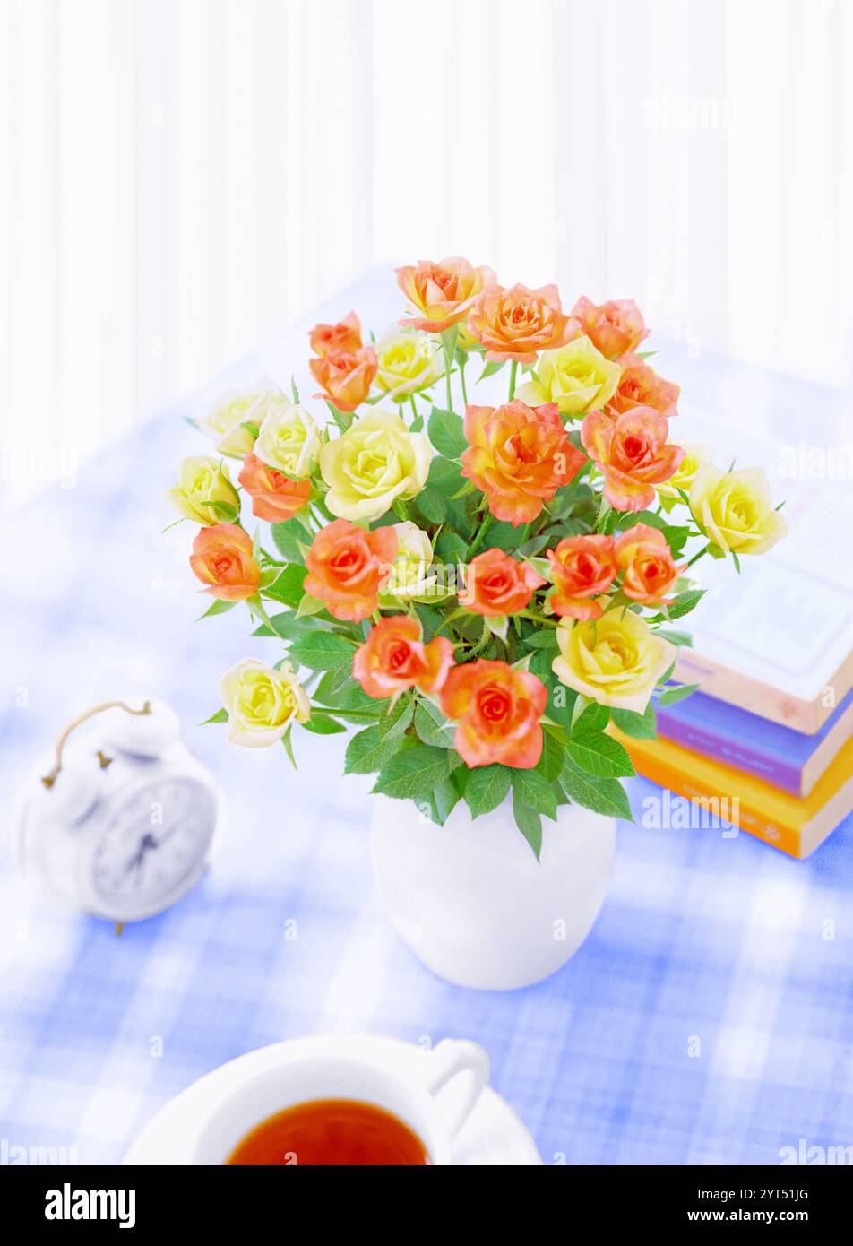Mini roses, tea and clock Stock Photo - Alamy