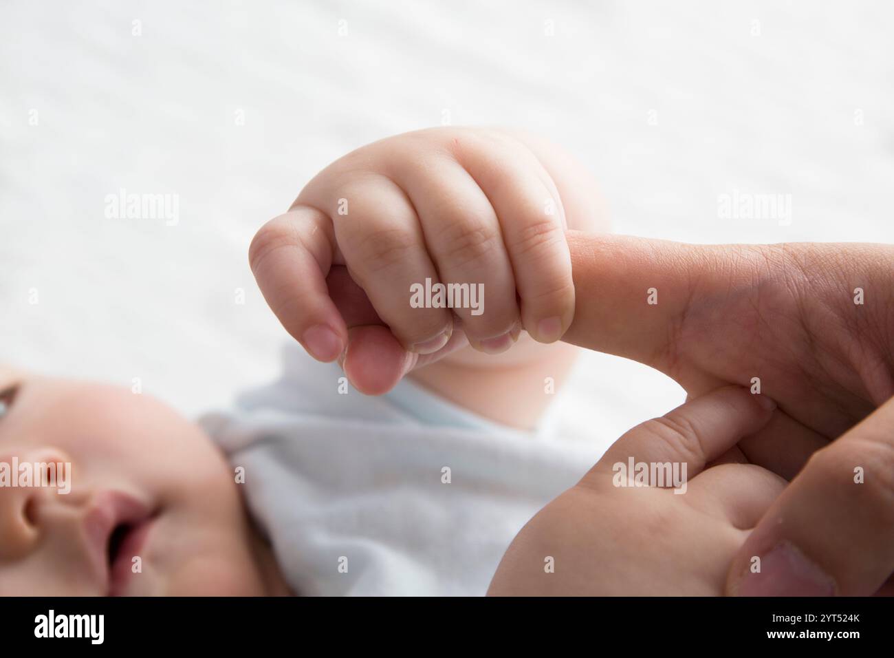 Baby's hand clasping adult's fingers Stock Photo - Alamy