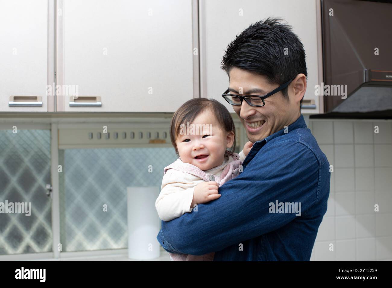 Father holding baby in kitchen Stock Photo - Alamy