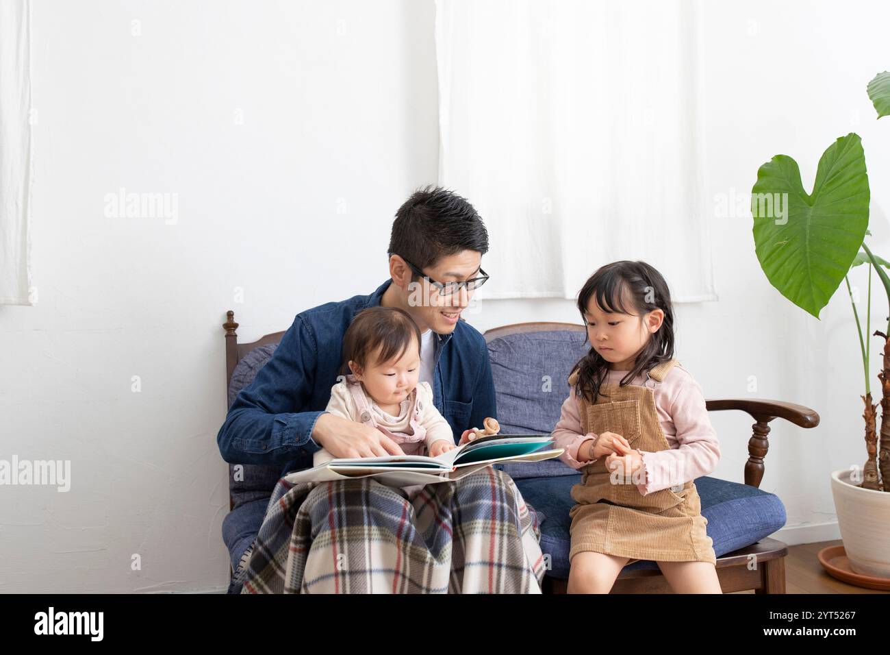 Father reading a picture book to his children Stock Photo - Alamy