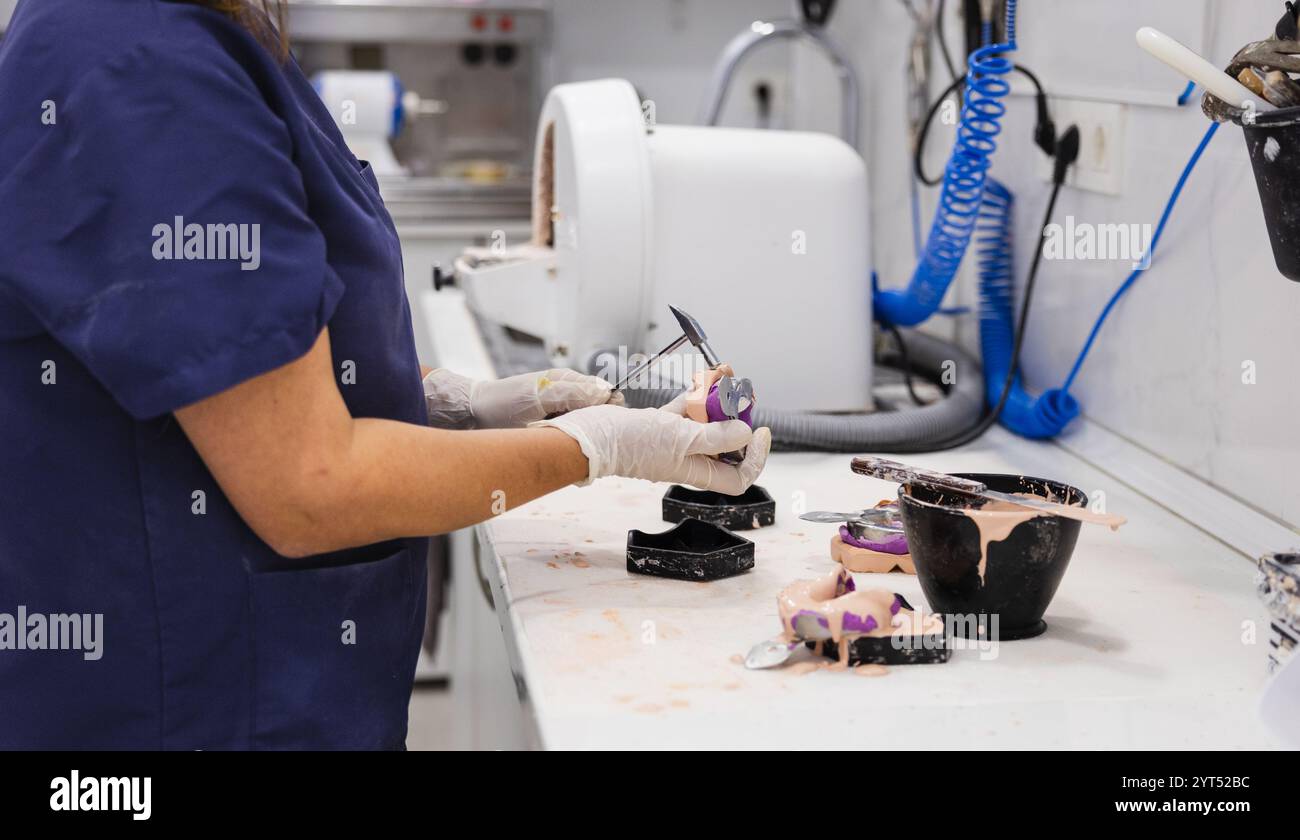 Close-up of an orthodontic technician cleaning a prosthetic mold in the ...