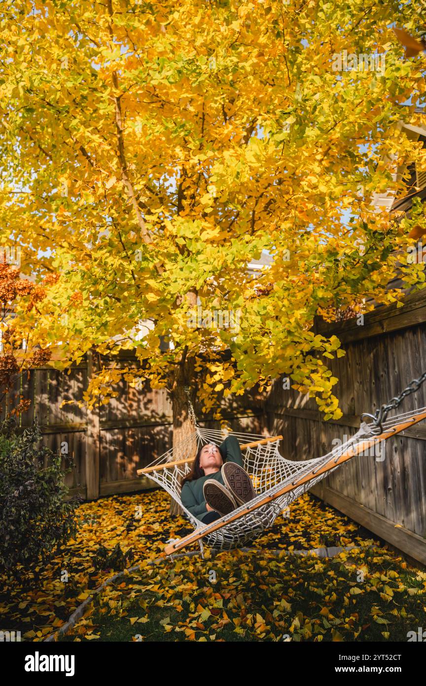 Woman relaxing under tree hi-res stock photography and images - Alamy