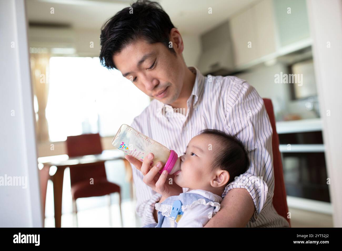 Father giving milk to baby Stock Photo - Alamy