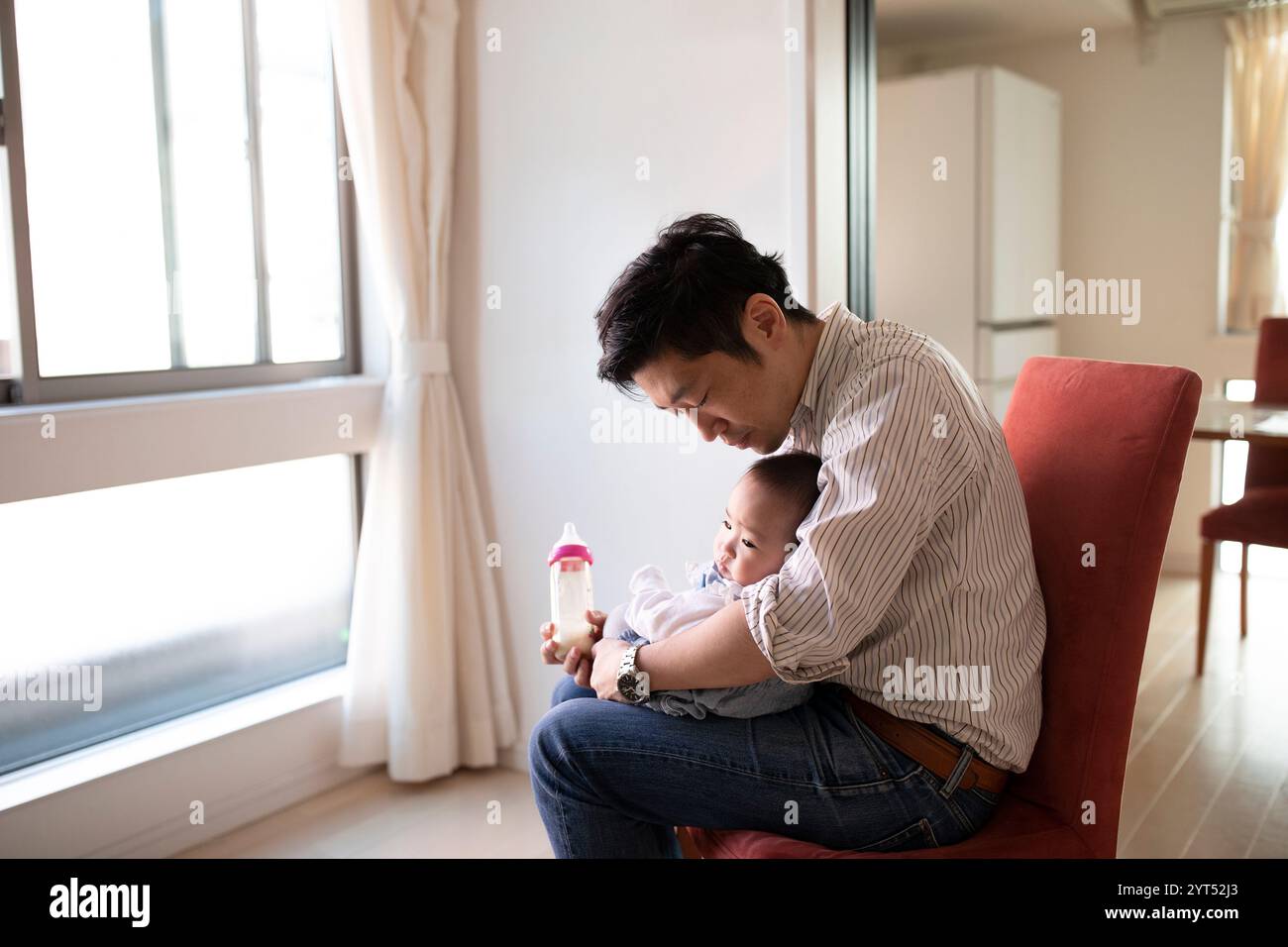 Father giving milk to baby Stock Photo - Alamy