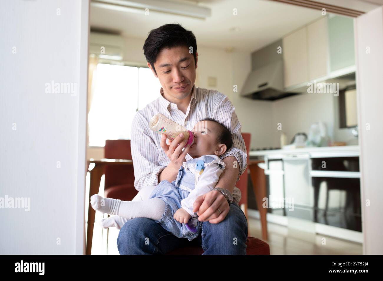 Father giving milk to baby Stock Photo - Alamy