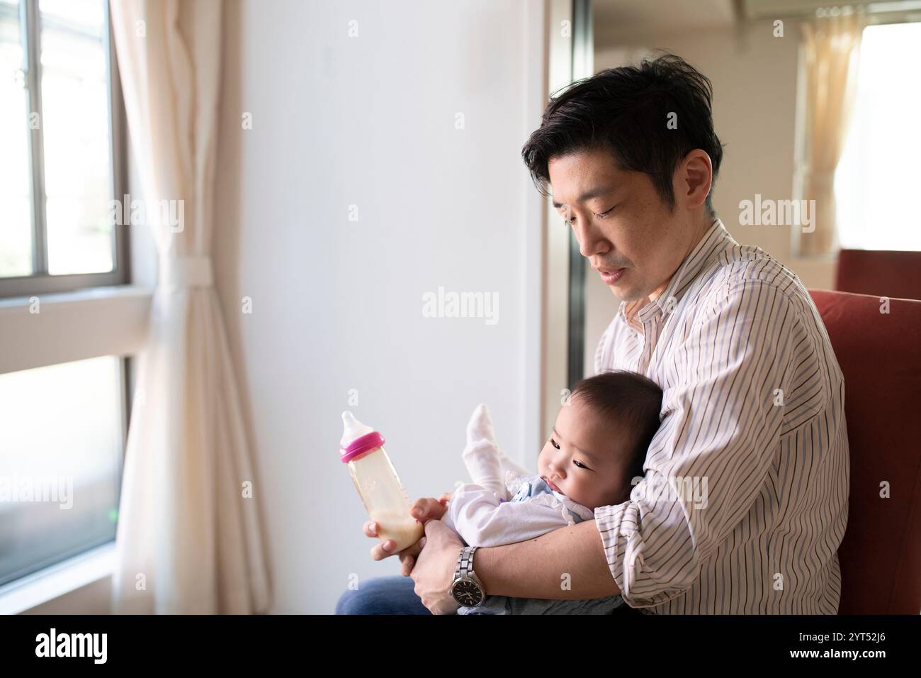 Father giving milk to baby Stock Photo - Alamy