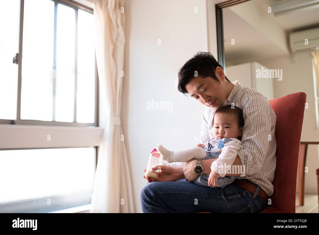 Father giving milk to baby Stock Photo - Alamy