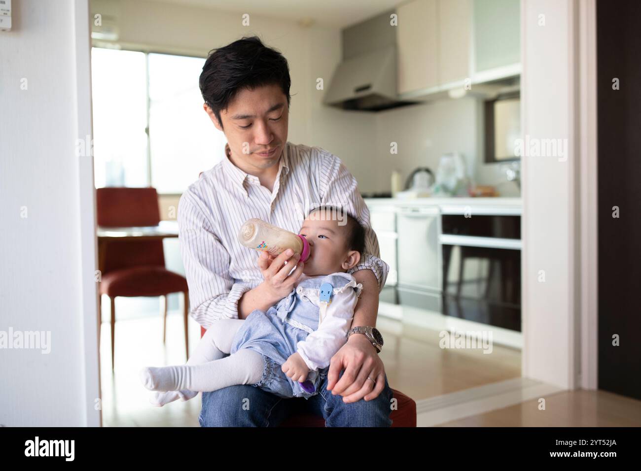 Father giving milk to baby Stock Photo - Alamy