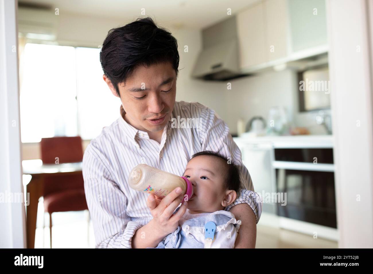 Father giving milk to baby Stock Photo - Alamy