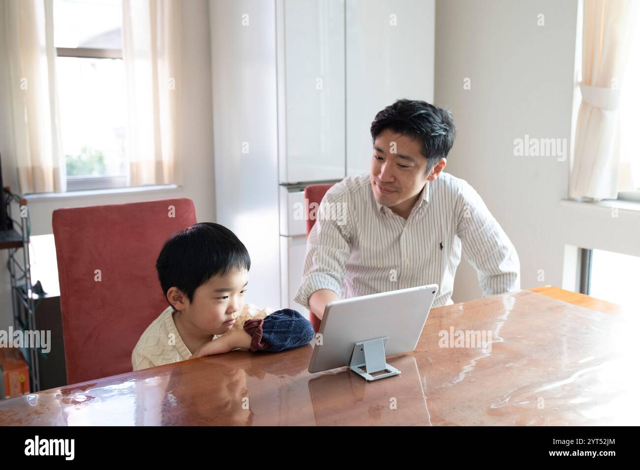 Parents and children looking at tablets Stock Photo - Alamy