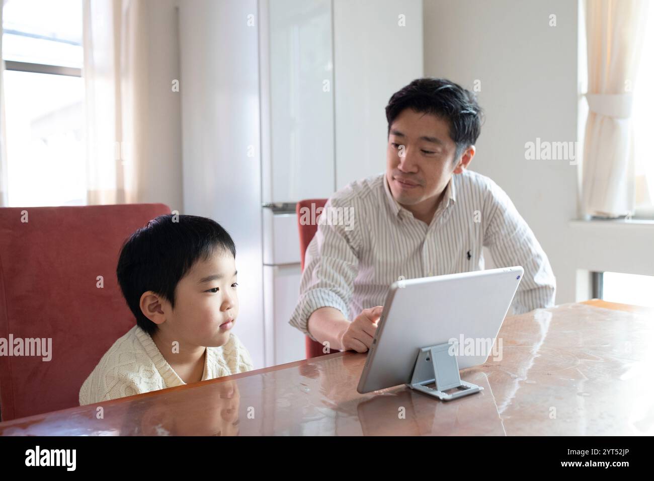 Parents and children looking at tablets Stock Photo - Alamy