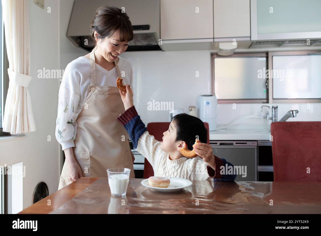 Boy sharing a snack with his mother Stock Photo - Alamy