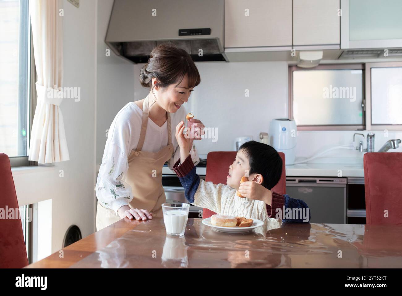 Boy sharing a snack with his mother Stock Photo - Alamy