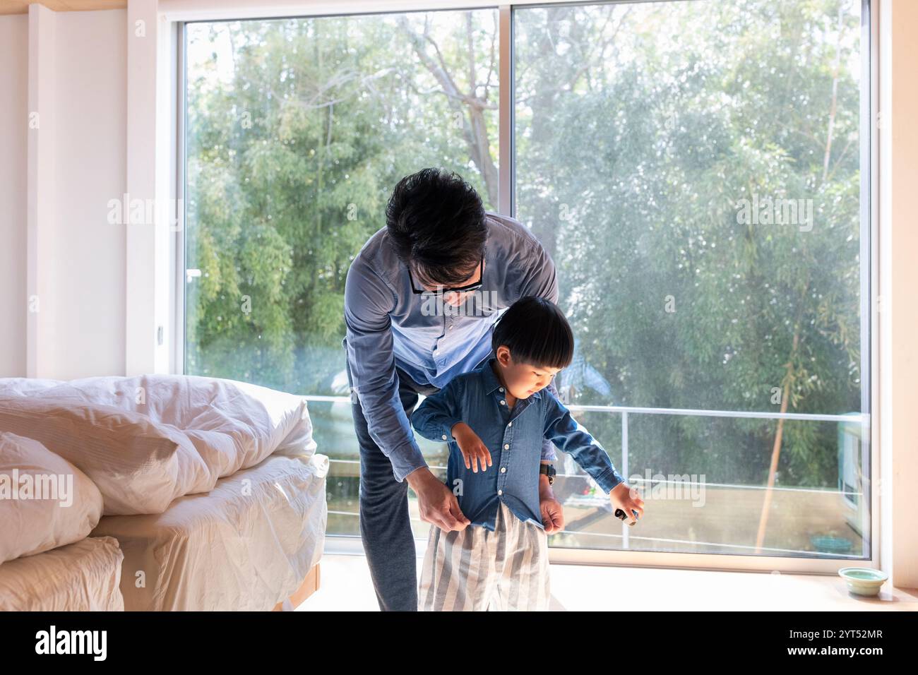 Father getting his child dressed Stock Photo - Alamy
