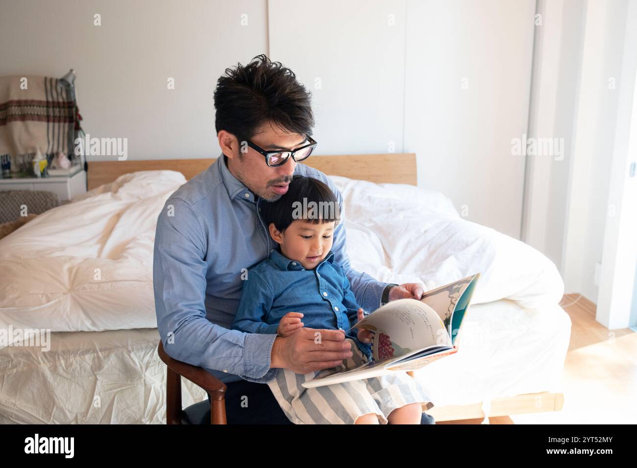 Parent and child reading a story to each other in their bedroom Stock ...