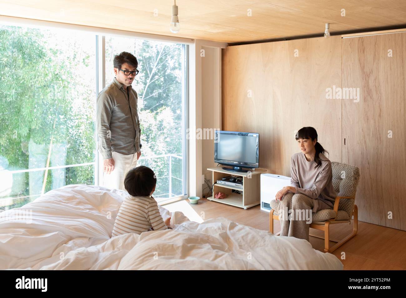 Family of three, parents and boy talking in bedroom Stock Photo - Alamy