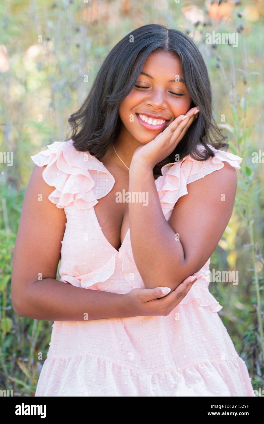 Model in the park with eyes closed and hand on cheek Stock Photo - Alamy