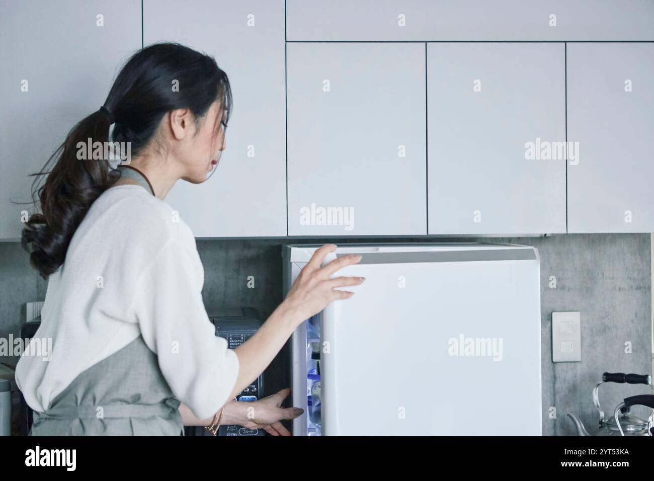 Woman opening fridge Stock Photo - Alamy