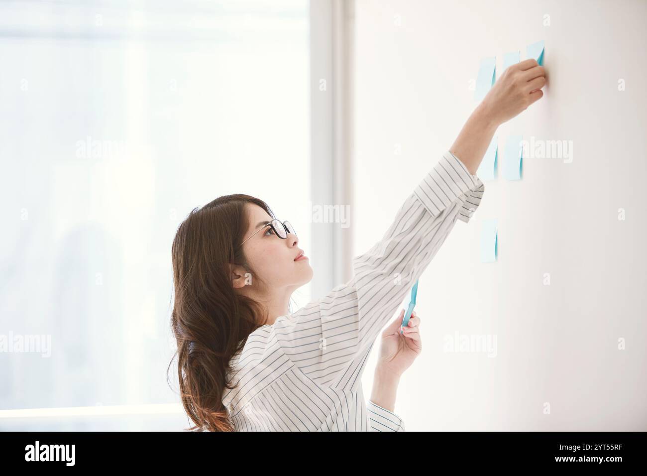Woman pasting labels on the wall Stock Photo - Alamy