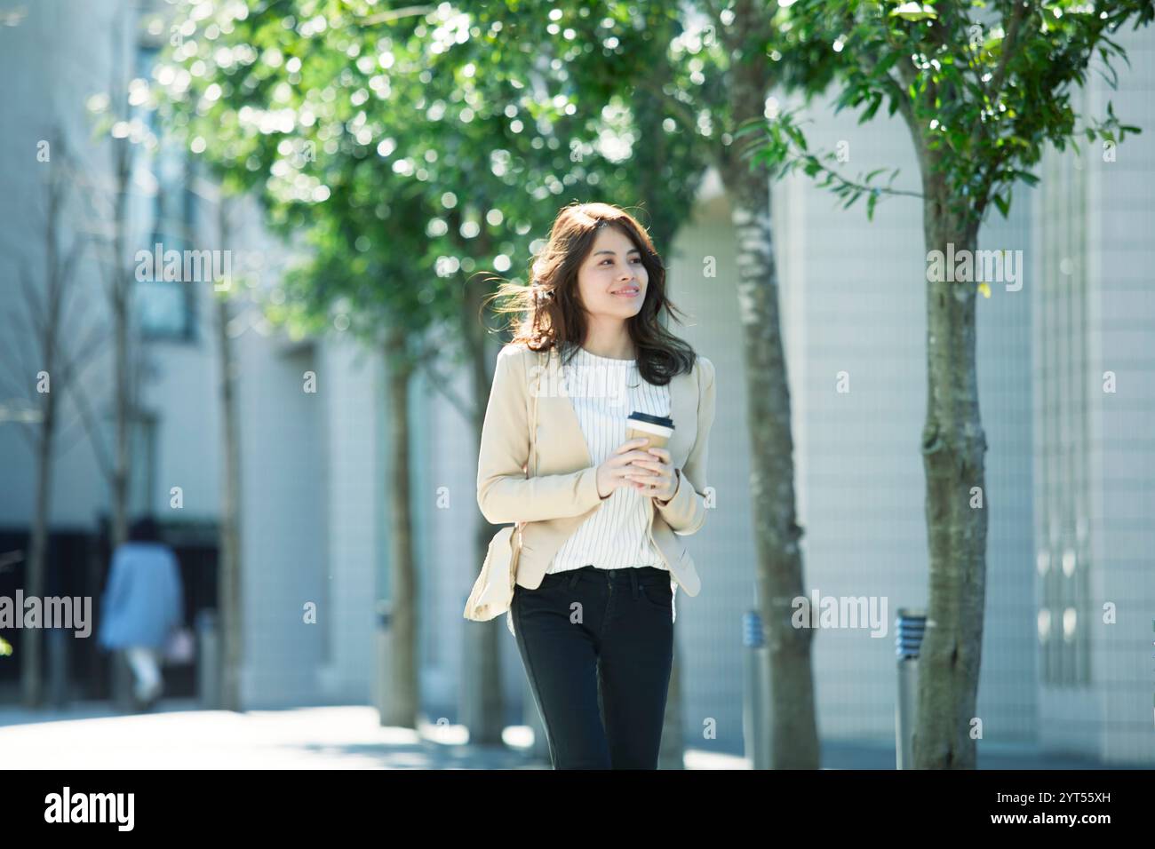 Woman walking in front of building Stock Photo - Alamy