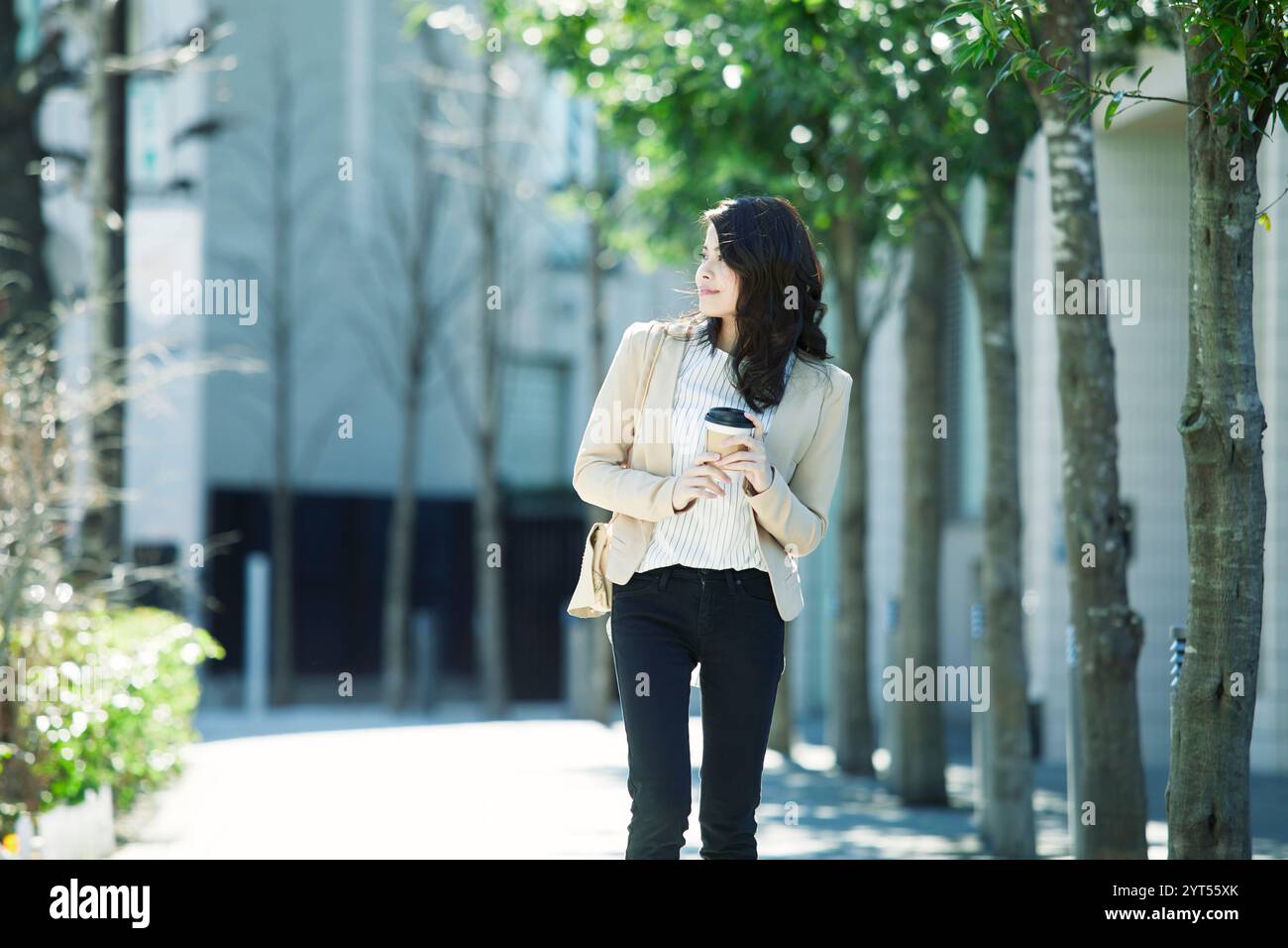 Woman walking in front of building Stock Photo - Alamy