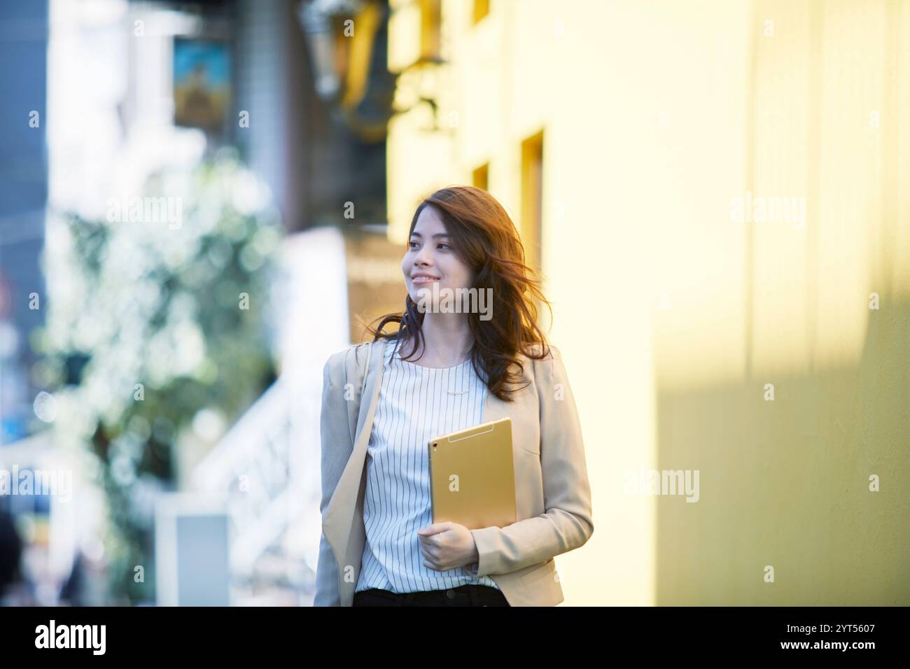Woman walking in front of building Stock Photo - Alamy