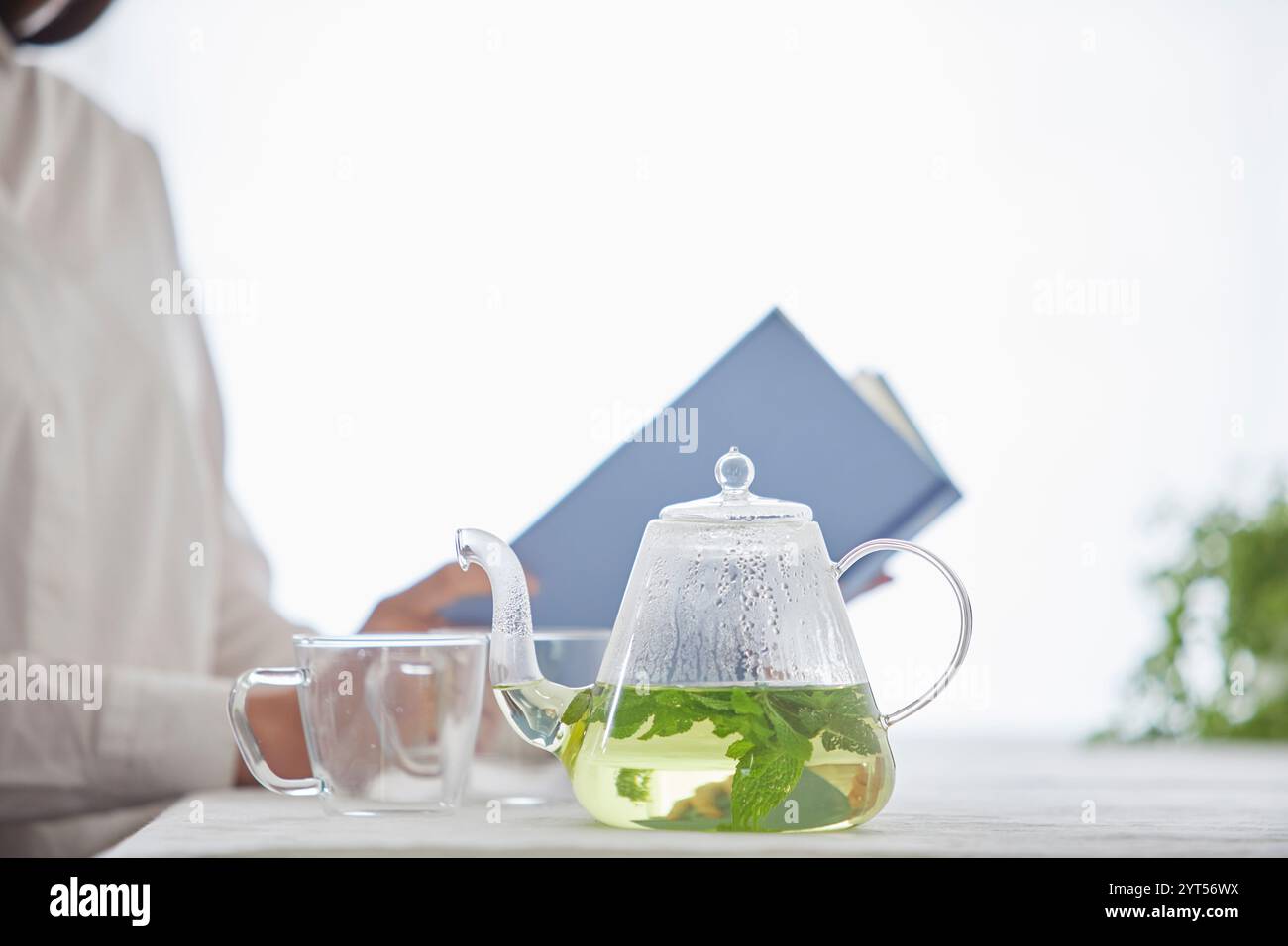 Teapot and woman drinking tea Stock Photo - Alamy
