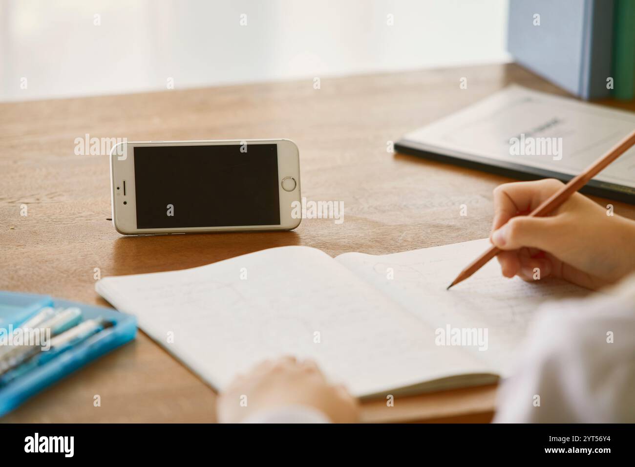 Female student studying while looking at her smartphone Stock Photo - Alamy