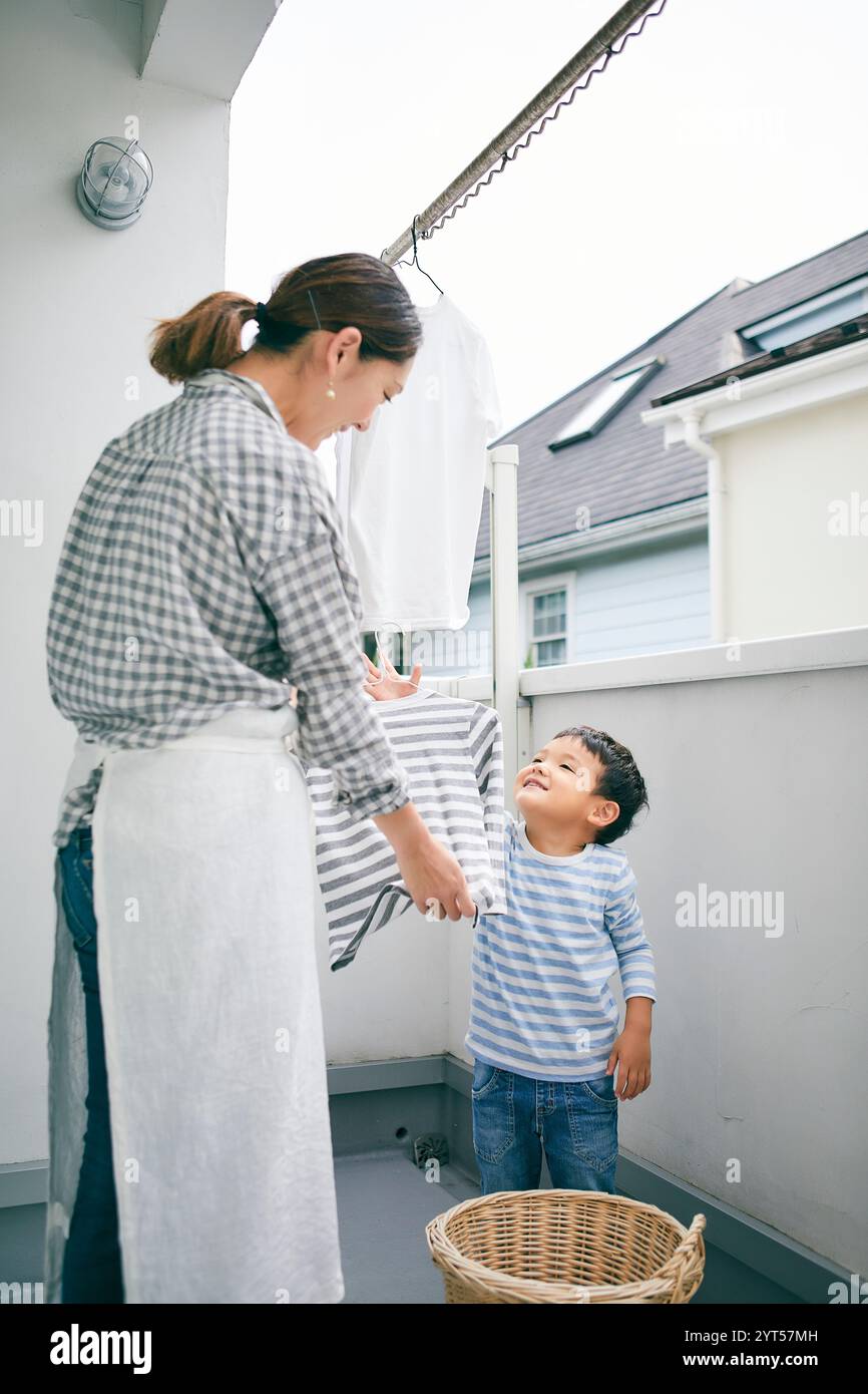 Woman and boy drying laundry Stock Photo - Alamy