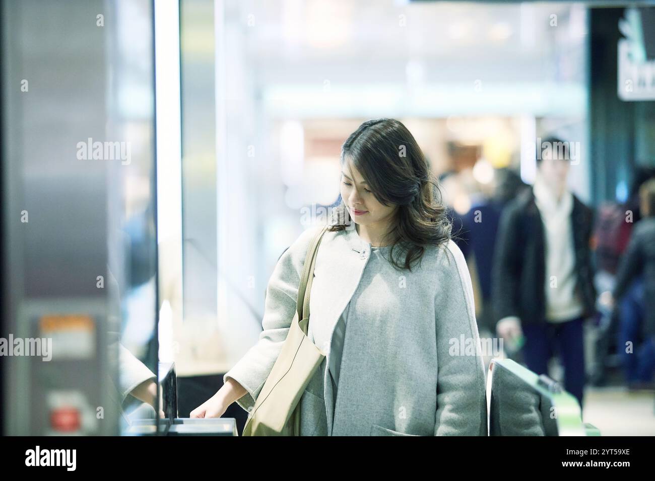 Woman going through ticket gate Stock Photo - Alamy