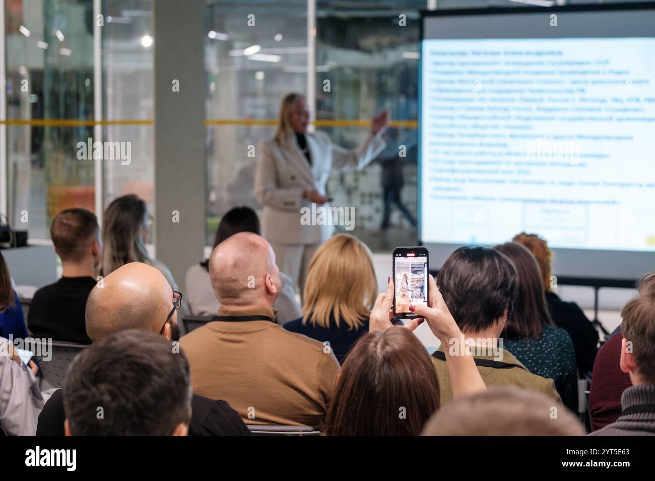 Business professional presenting to attentive audience in conference ...