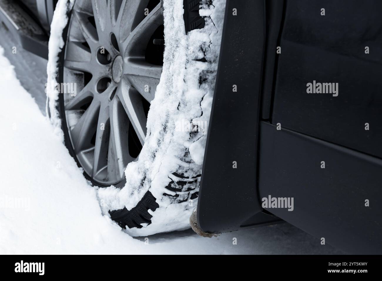 Car wheel on snow tire with metal studs. Closeup photo with selective ...