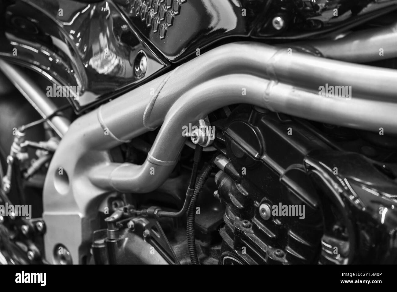 Sport bike engine fragment with exhaust pipes, close up black and white ...