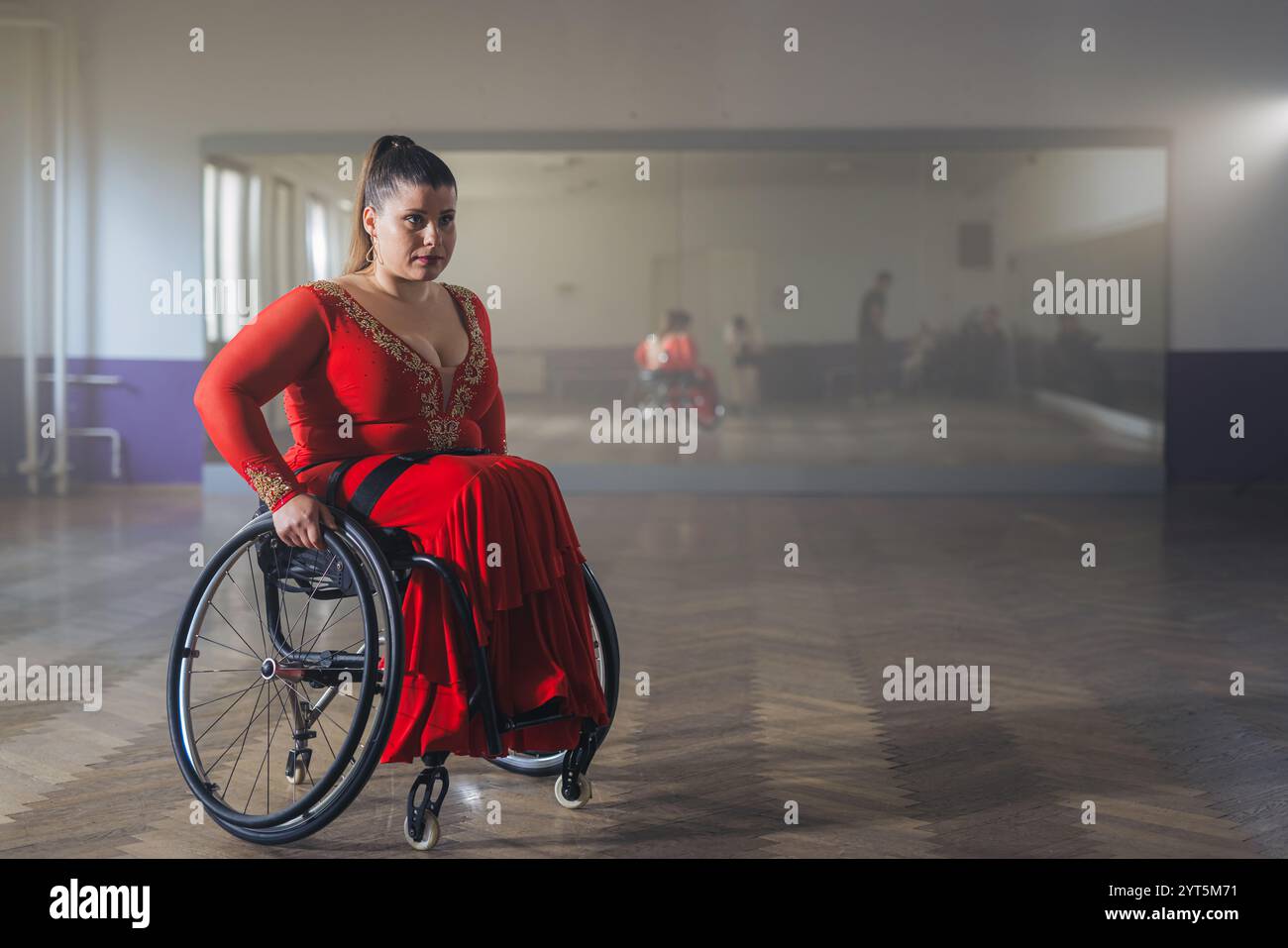 Smiling confident young woman enjoying performing wheelchair dance in a ...