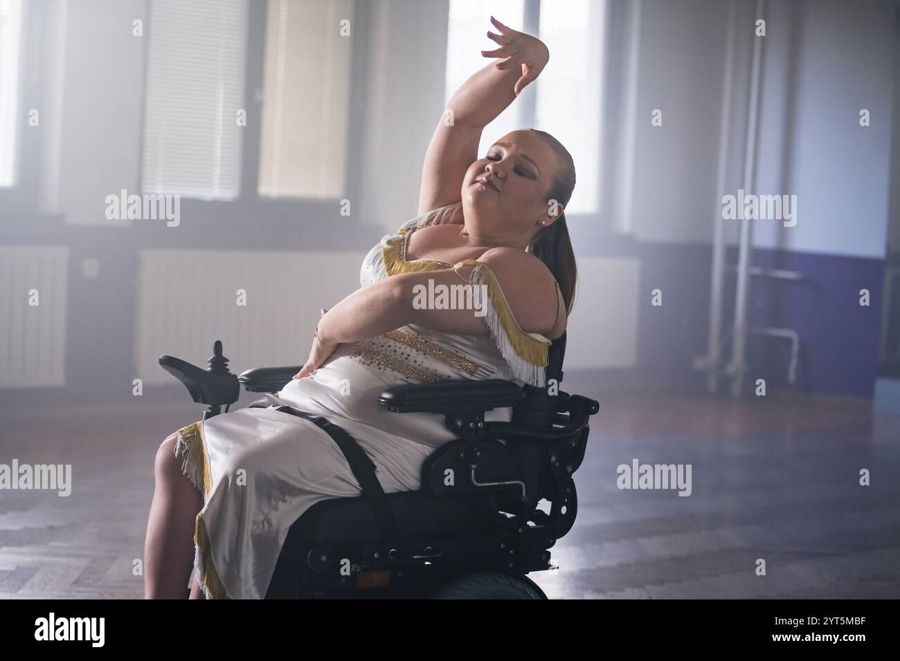 Woman on electric wheelchair performing para dance choreography. Aspiration, determination, and ...
