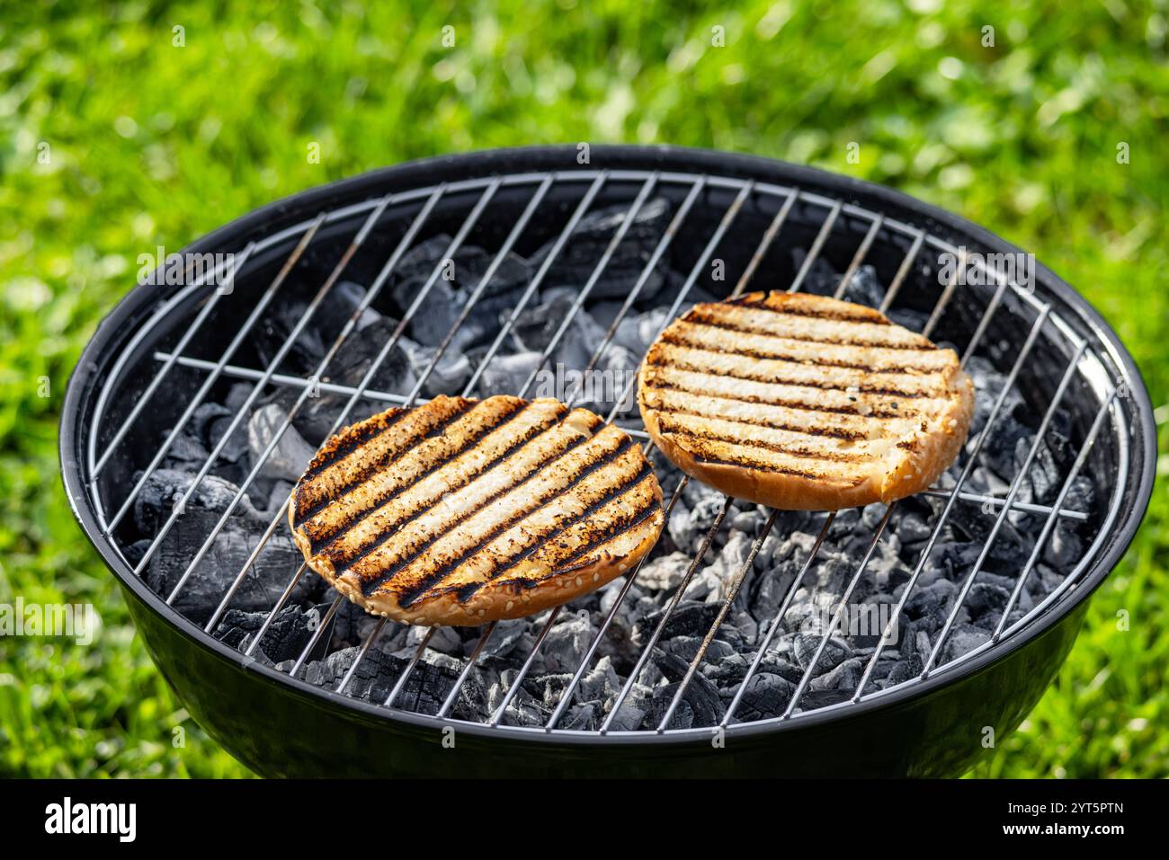 burger bread bun grilling on charcoal grill in the garden Stock Photo ...