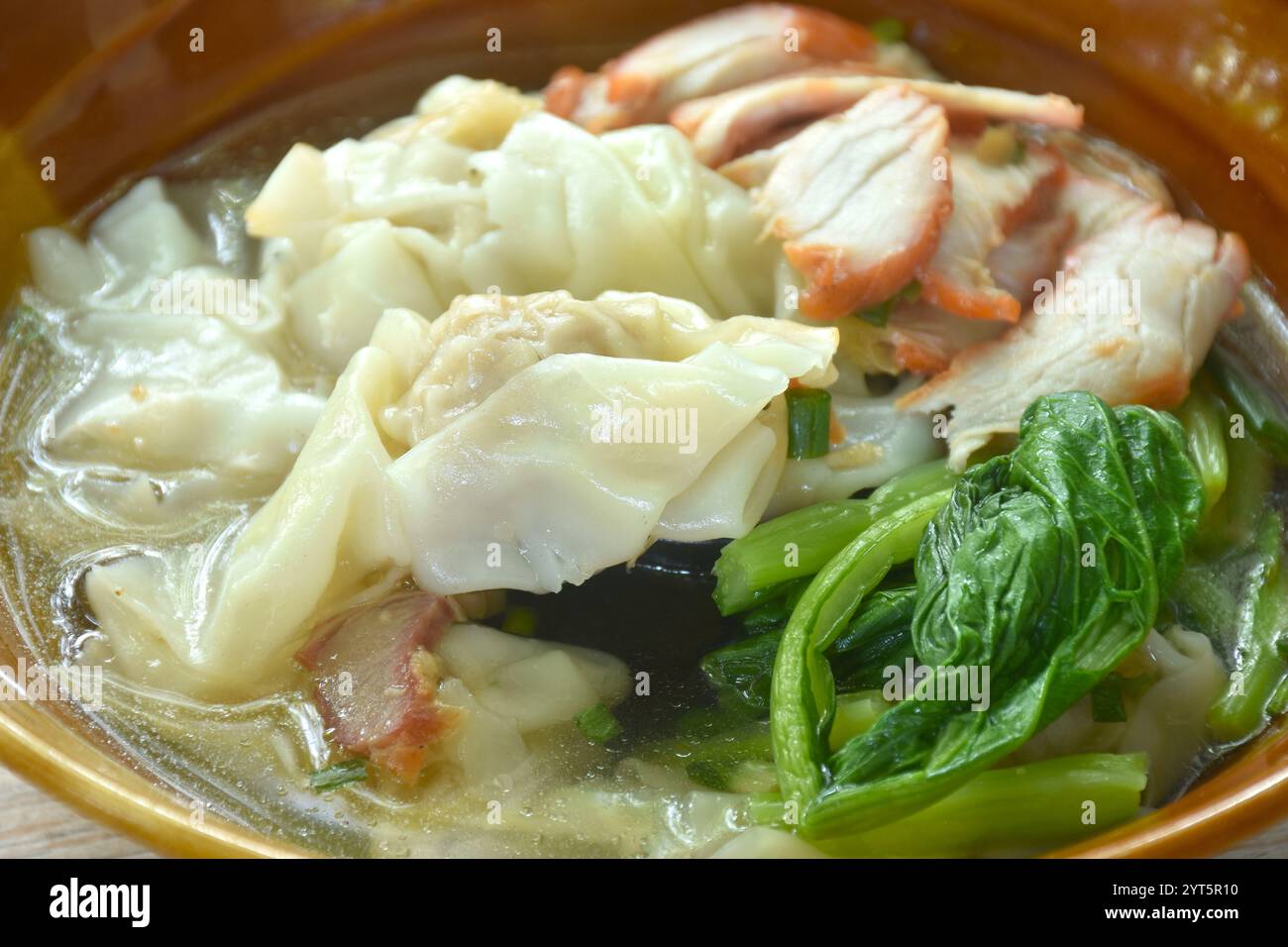 Chinese dumpling topping slice red barbecue pork with clear soup on ...