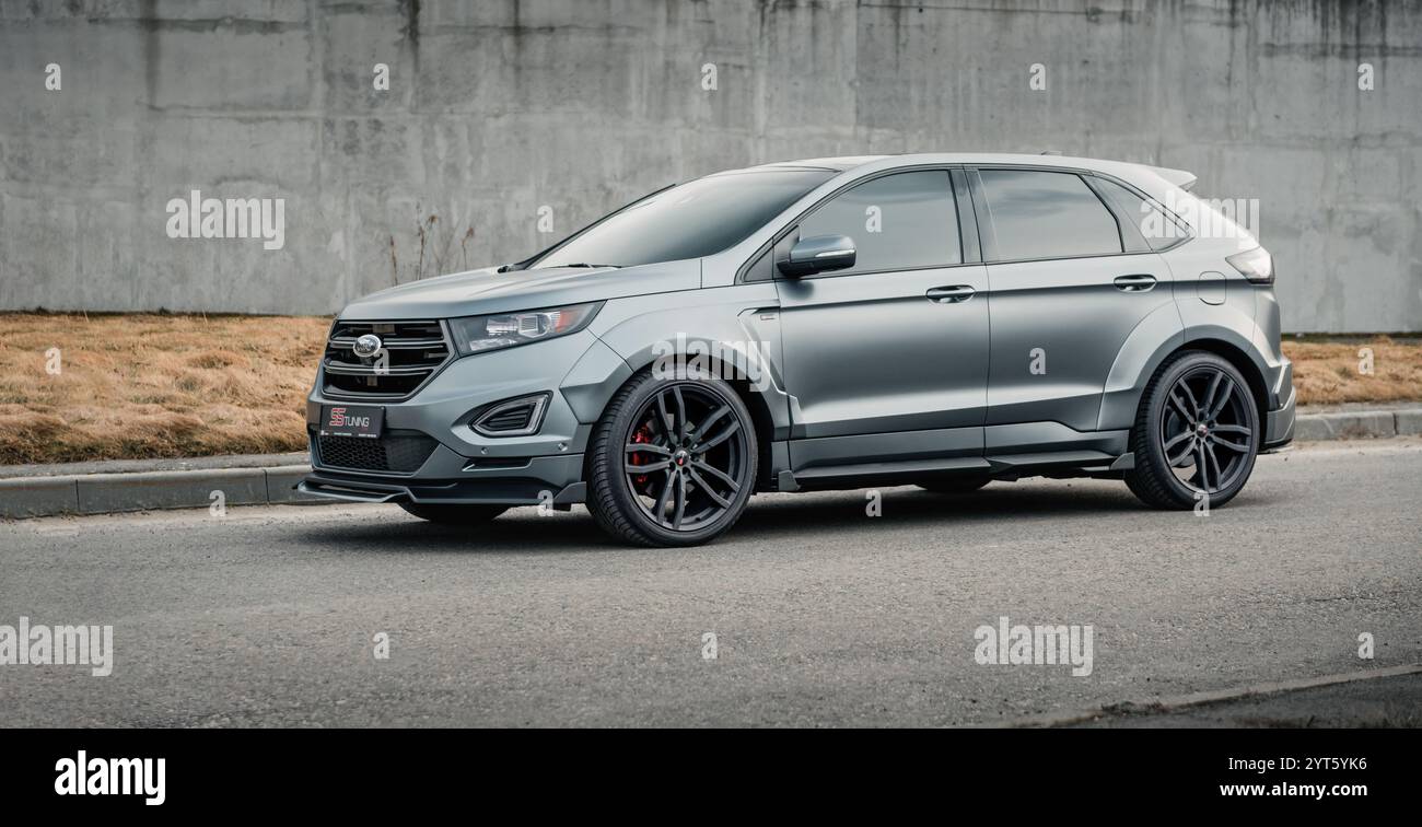 Satin grey Ford Edge on a city street. Front three quarter view of ...