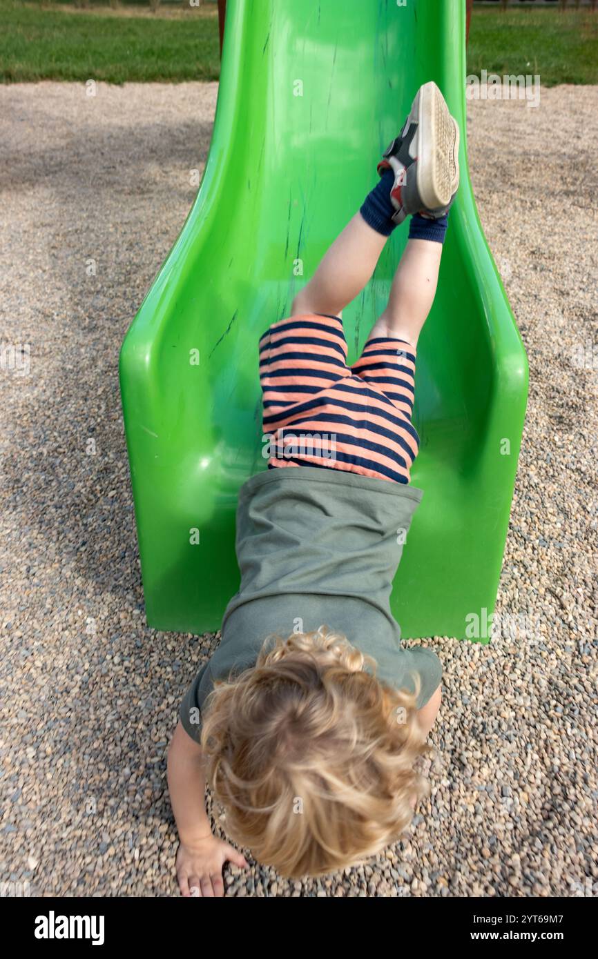 A little boy falls headfirst down a slide Stock Photo - Alamy