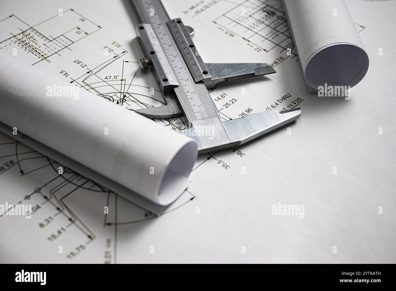 Caliper rests on rolled blueprints, highlighting the importance of ...