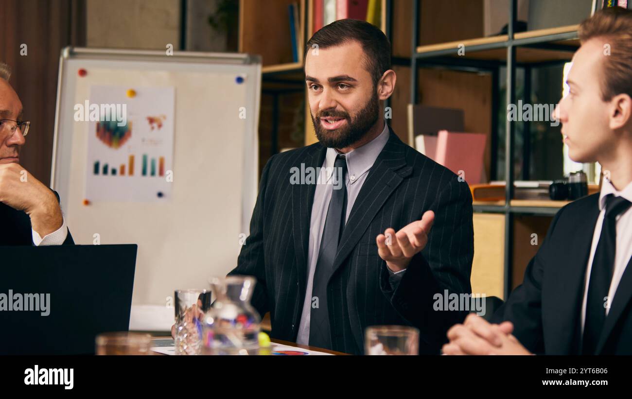 Group of business professionals in formal attire discussing charts and ...
