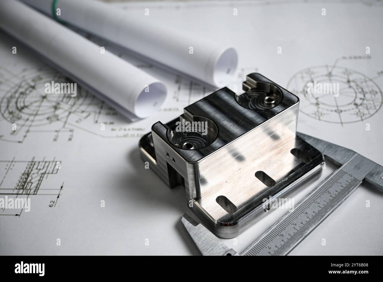 Metal machined part being measured with a caliper, placed on top of ...
