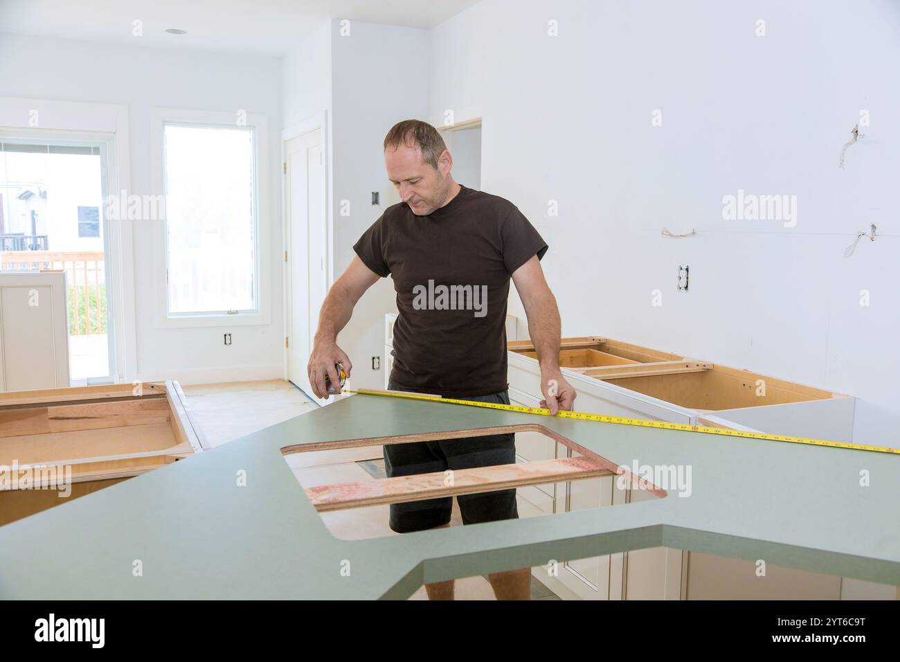 Contractor measures countertop in newly renovated kitchen, ensuring ...