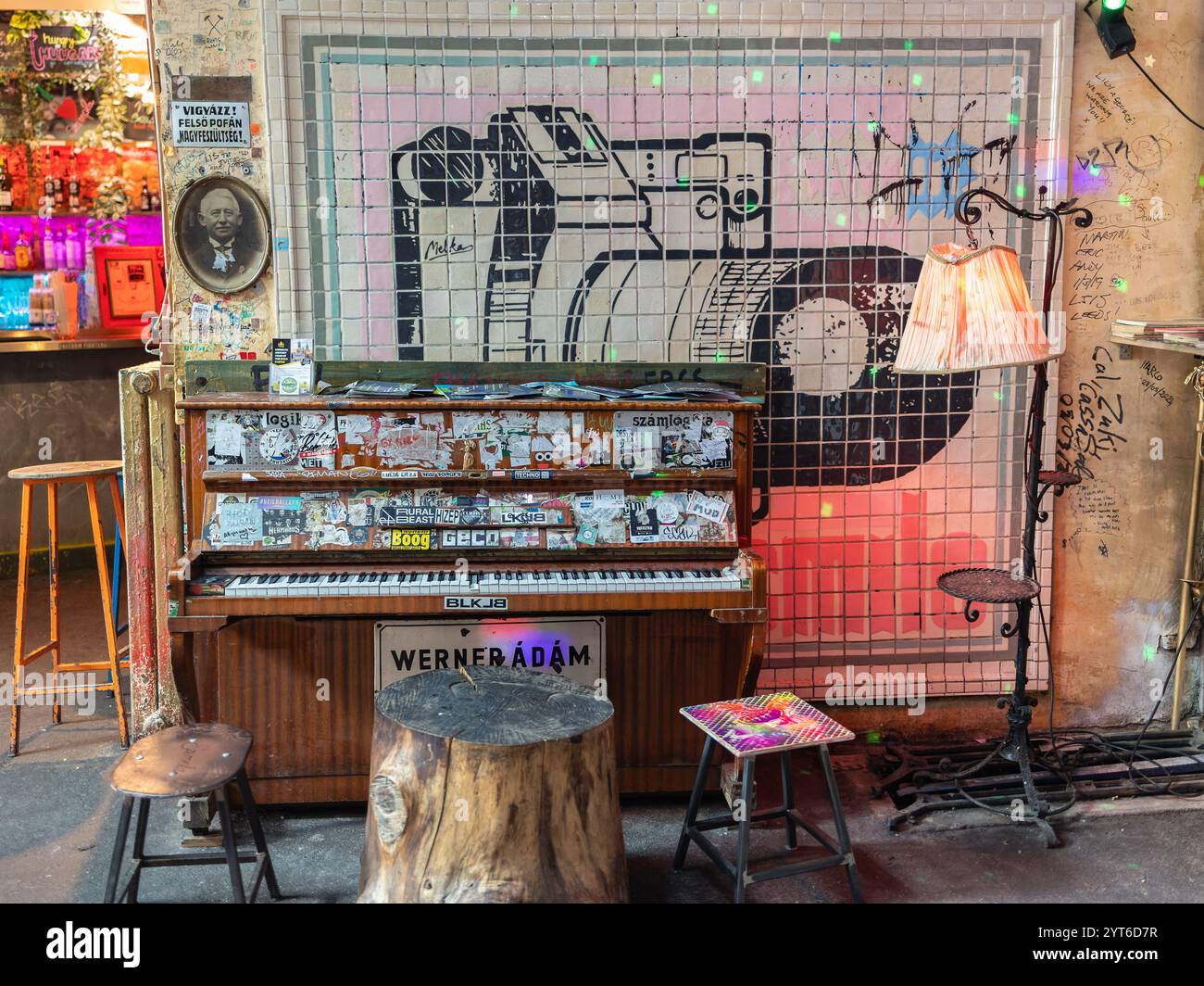 Vintage and Worn-Out Piano Covered in Stickers in a Dimly Lit Room ...
