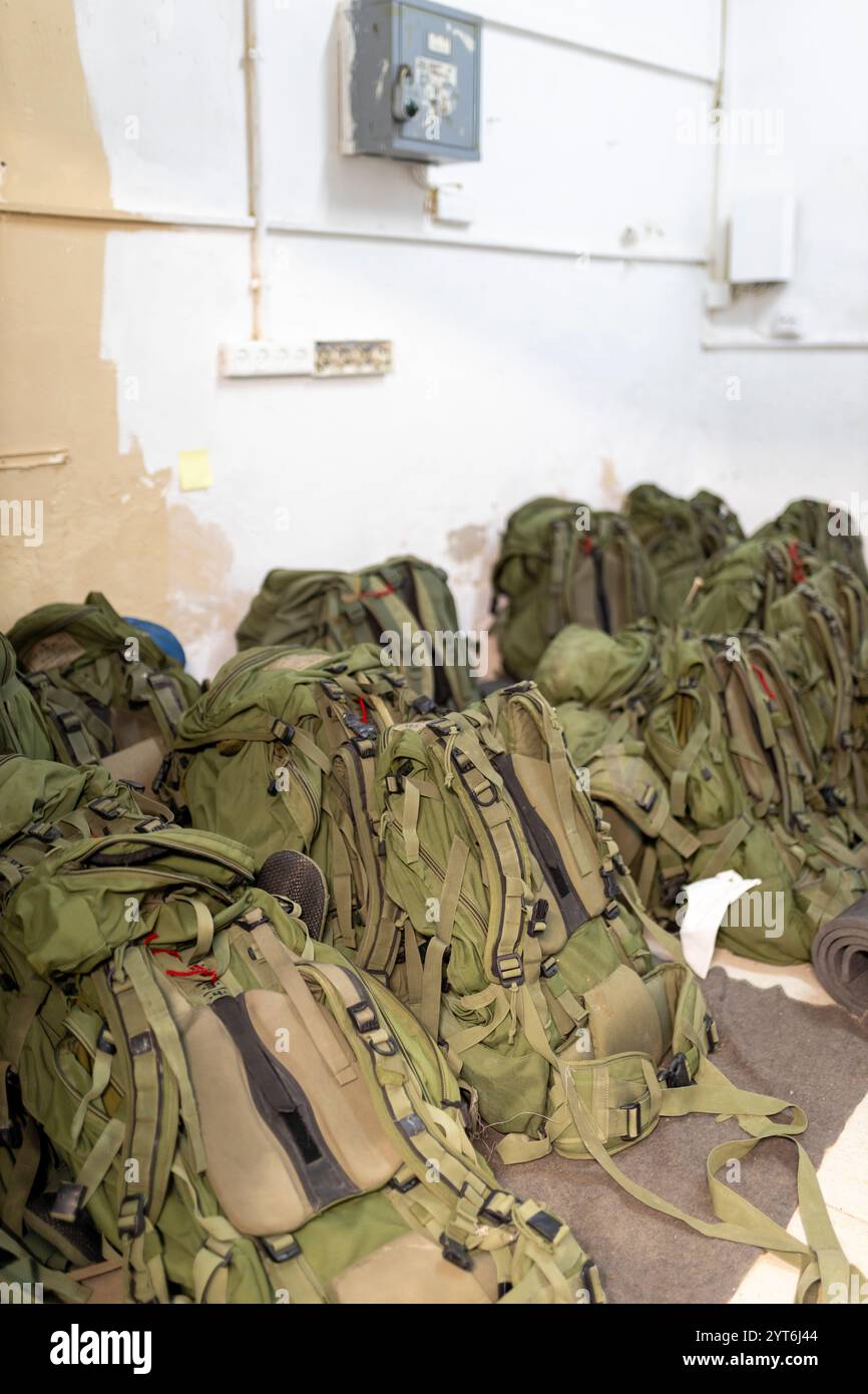 Decommissioned military backpacks, worn and weathered, are stored on a ...