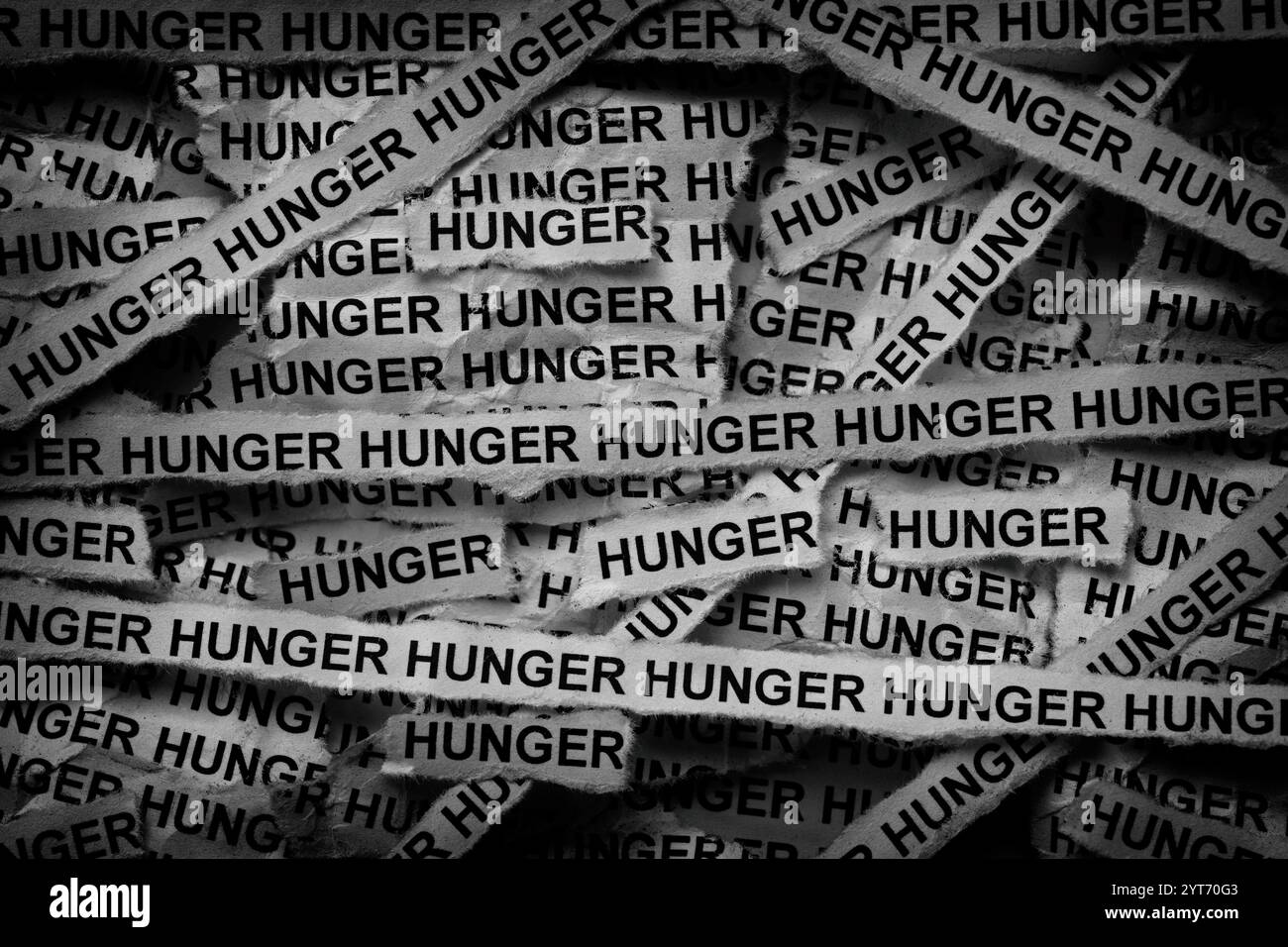 Strips of newspaper with the words Hunger typed on them. Black and ...