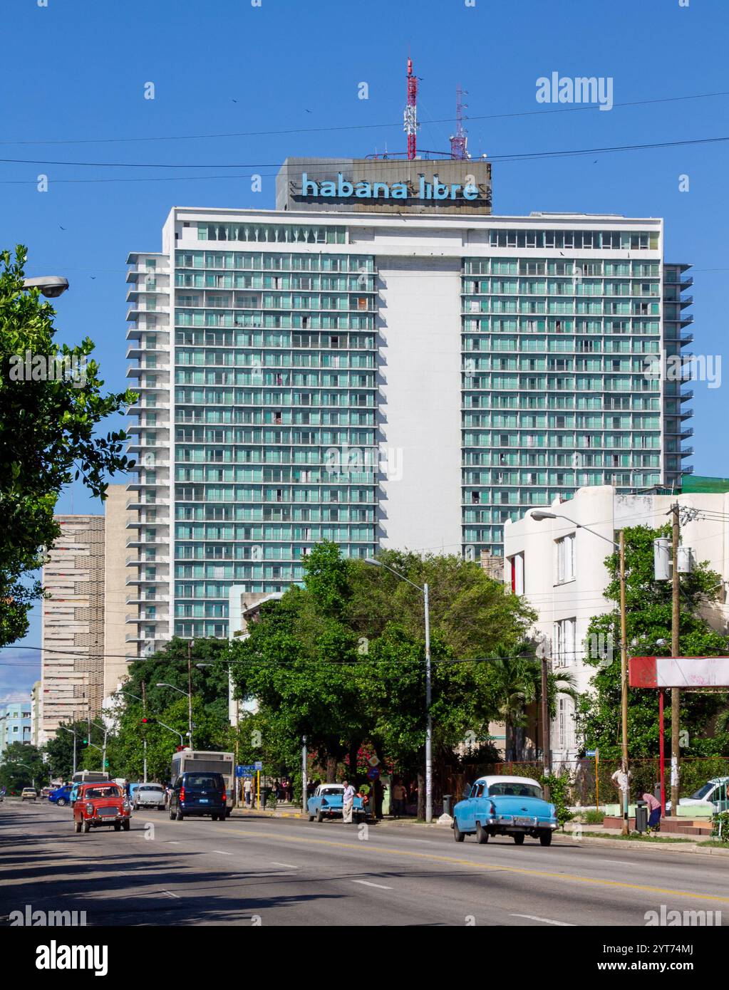 The famous Habana Libre hotel and vintage cars on the street, La Habana ...