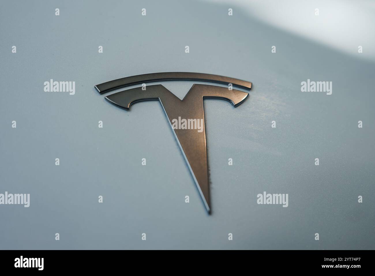 Close Up of Tesla Logo on Metallic Surface with Light Gray Background ...